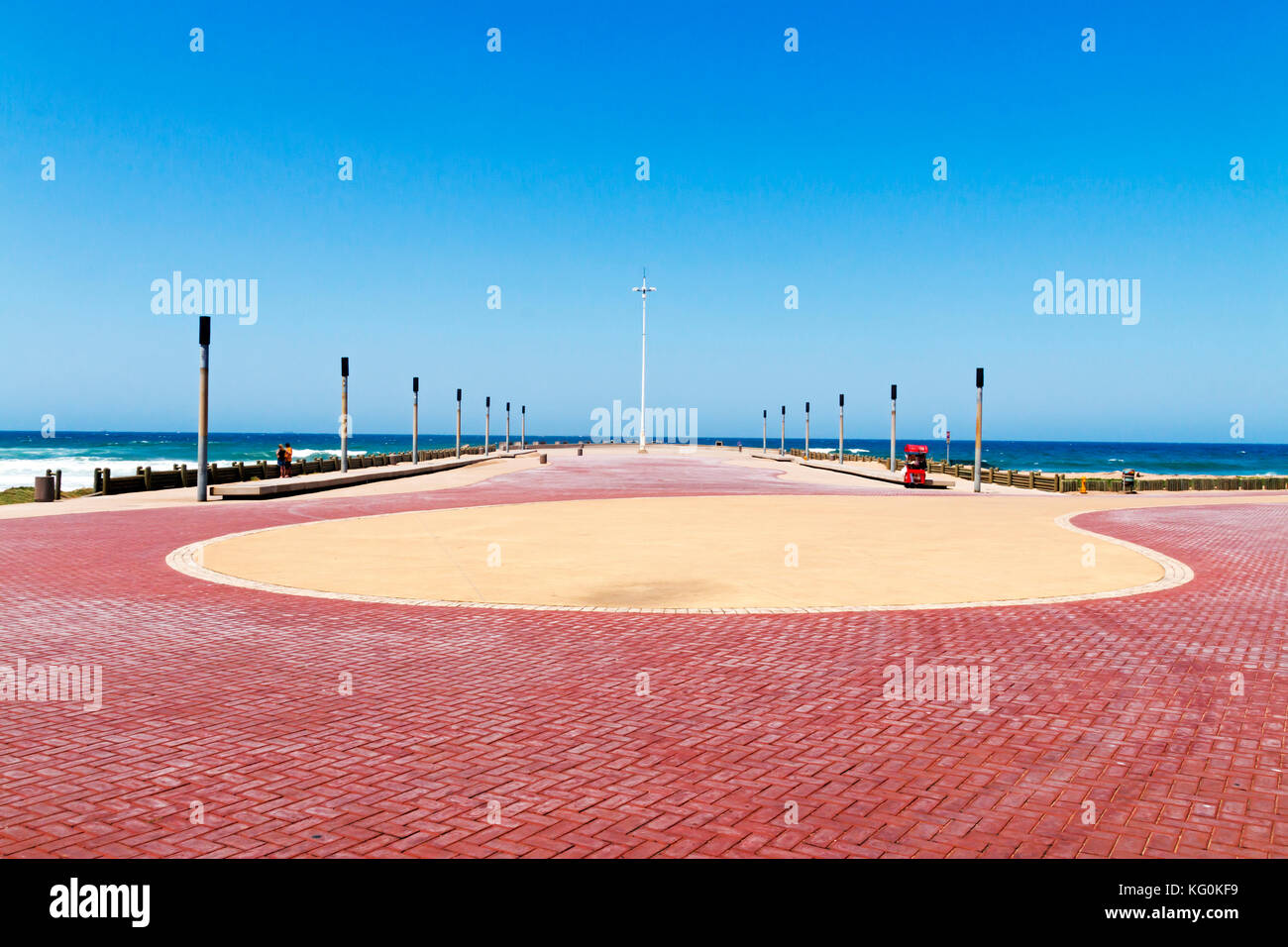 Empty red paved promenade pattern and texture against sea and blue sky ...
