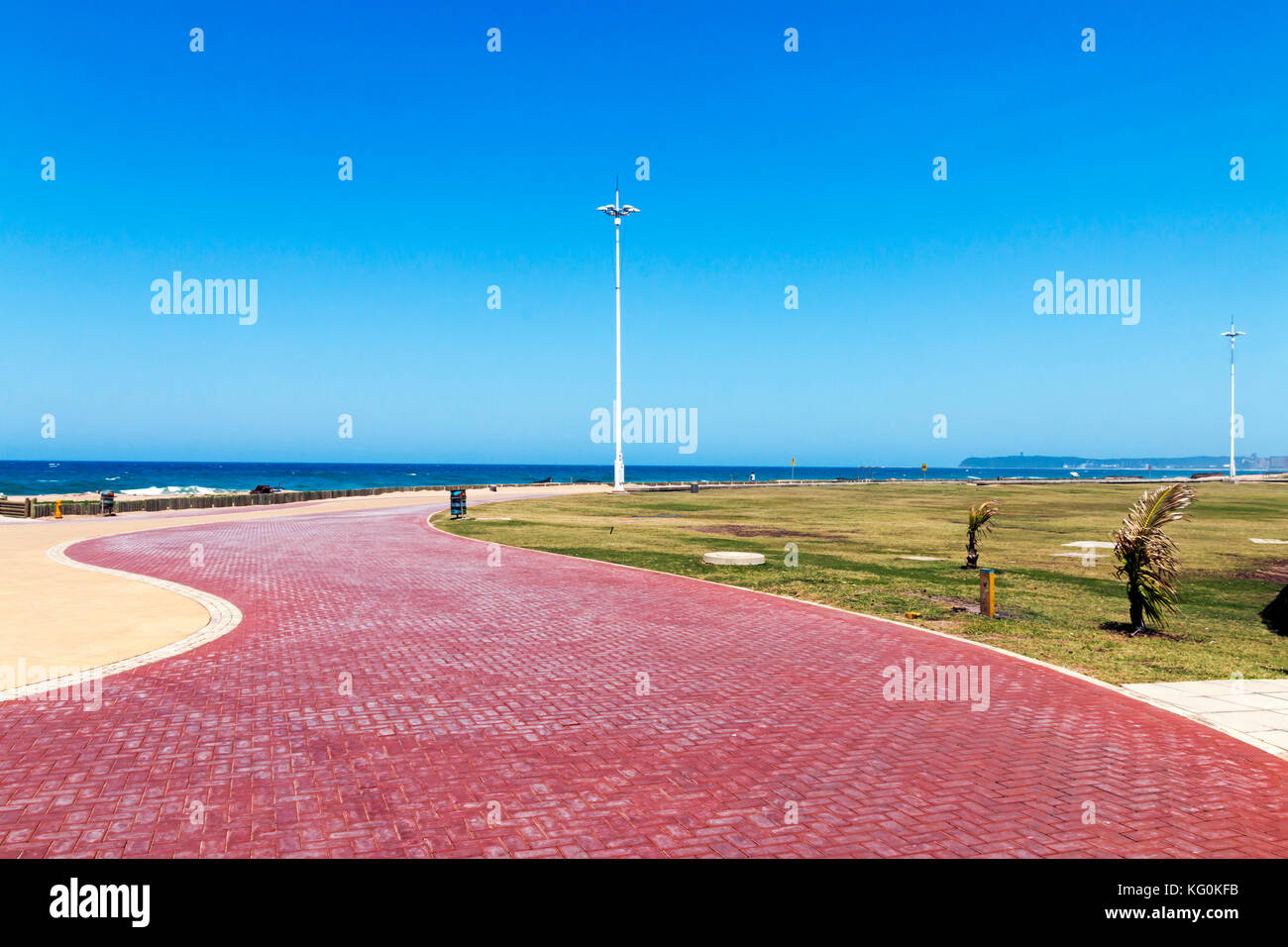 Empty red paved promenade pattern and texture against sea and blue sky ...