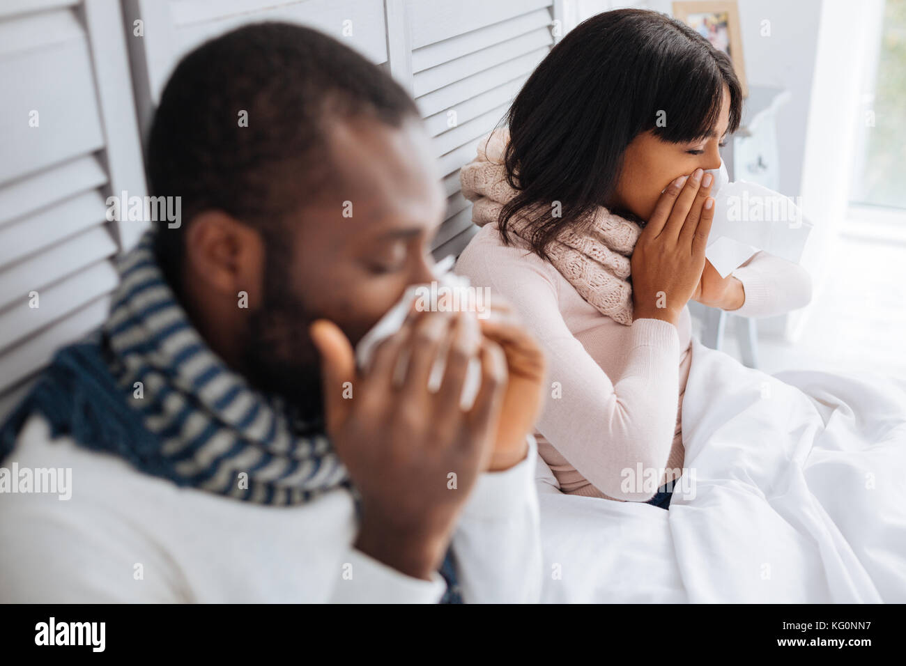 Two young people sneezing at the same time Stock Photo - Alamy