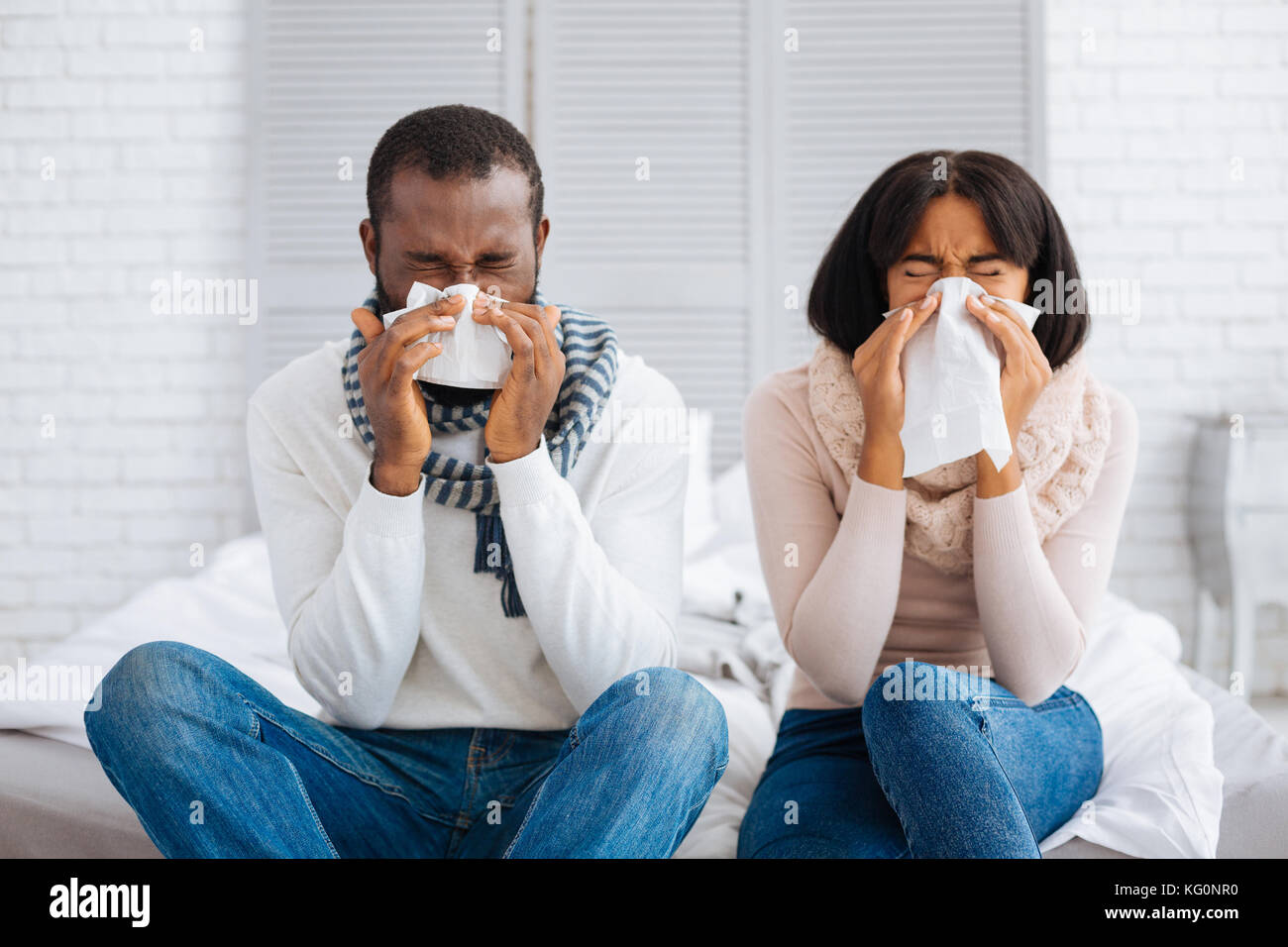 Cute young people sneezing simultaneously Stock Photo - Alamy