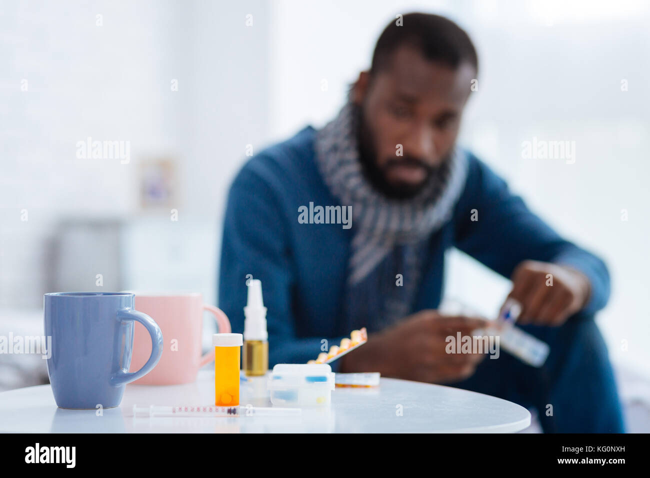 Sad ill man looking at the pills on his table Stock Photo - Alamy