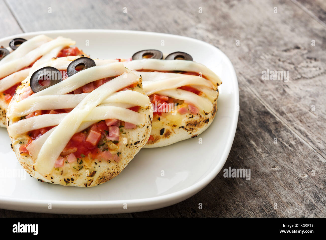 Halloween mummies mini pizzas on wooden table Stock Photo - Alamy