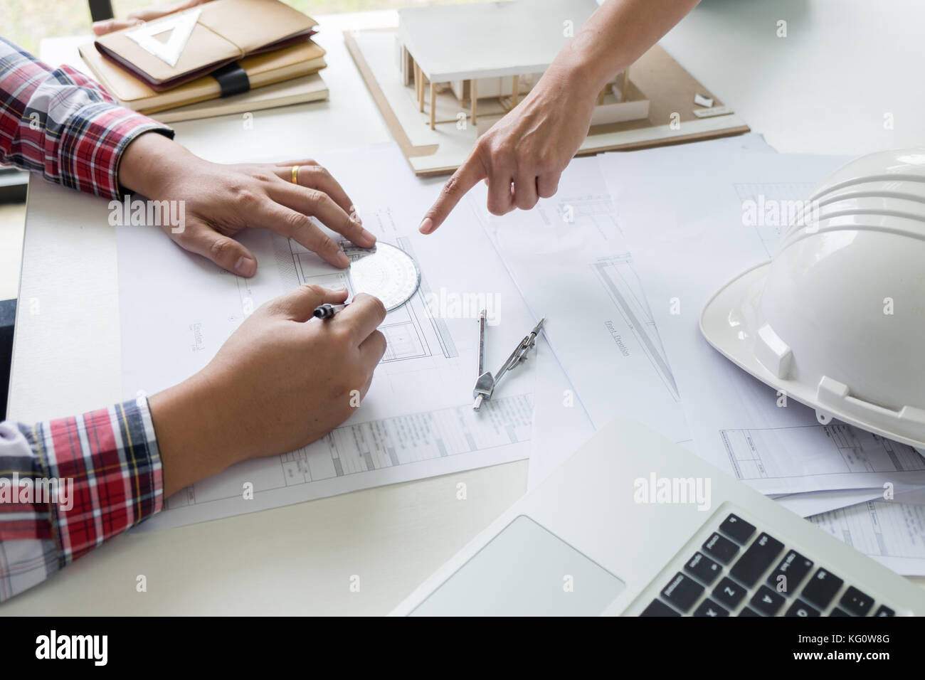 Architects engineer discussing at the table with blueprint - Closeup on ...