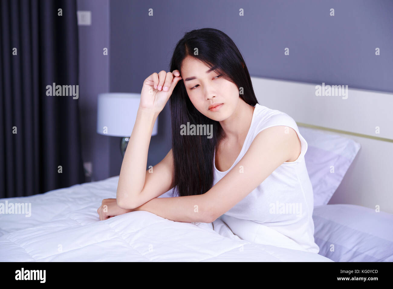 worried woman thinking on bed in the bedroom Stock Photo - Alamy