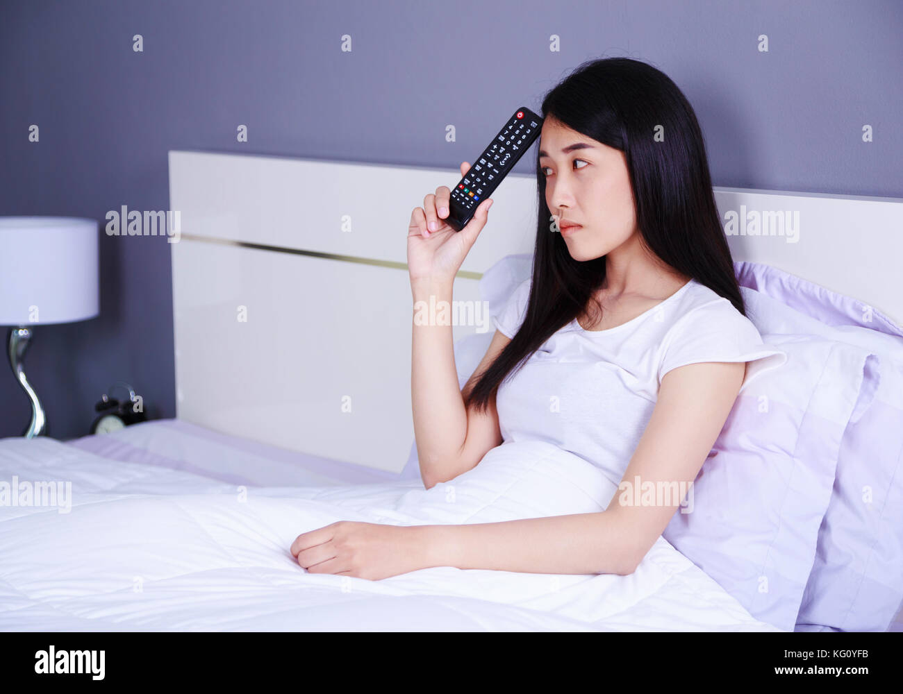 woman with tv remote control on bed in the bedroom Stock Photo - Alamy