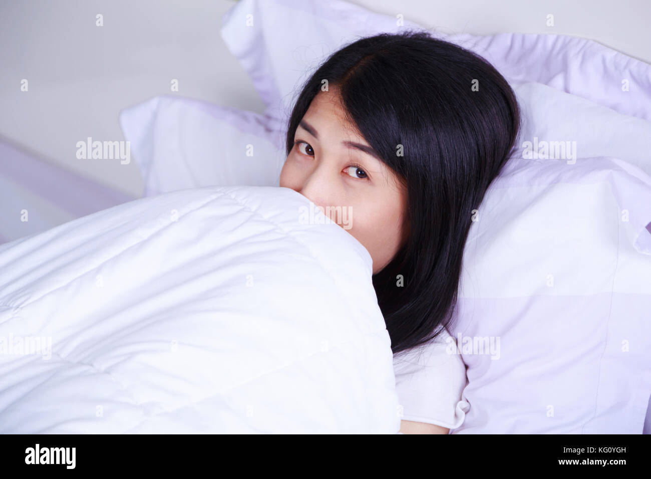 Woman hiding under a blanket on bed in the bedroom Stock Photo - Alamy