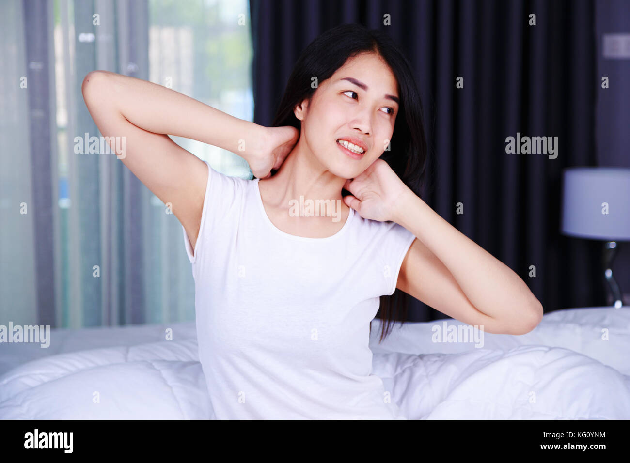 Woman waking up and hand raised on bed in the bedroom Stock Photo - Alamy