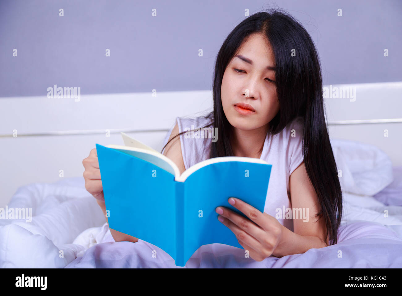 woman reading a book on bed in the bedroom at home Stock Photo - Alamy
