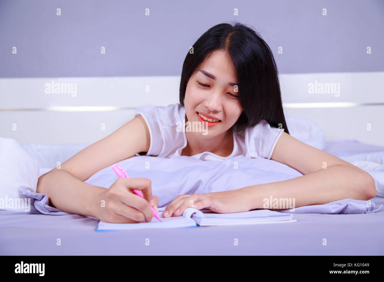 woman writing a book on her bed in the bedroom Stock Photo - Alamy