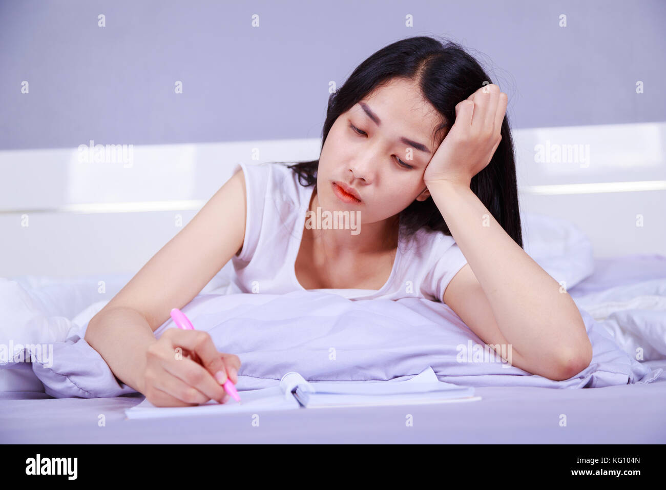 woman writing a book on her bed in the bedroom Stock Photo - Alamy