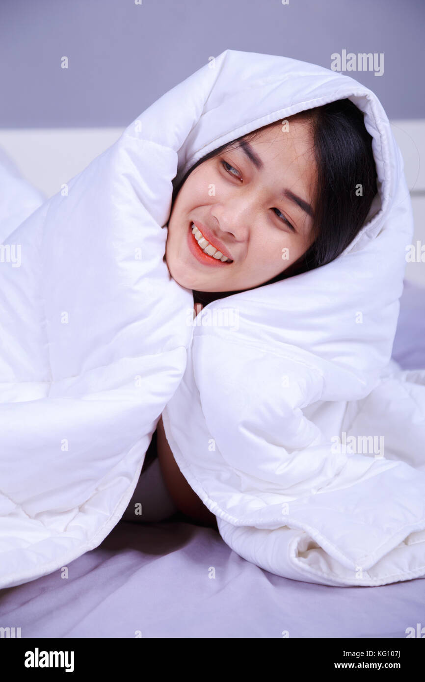 happy woman hiding under blanket on bed in the bedroom Stock Photo - Alamy