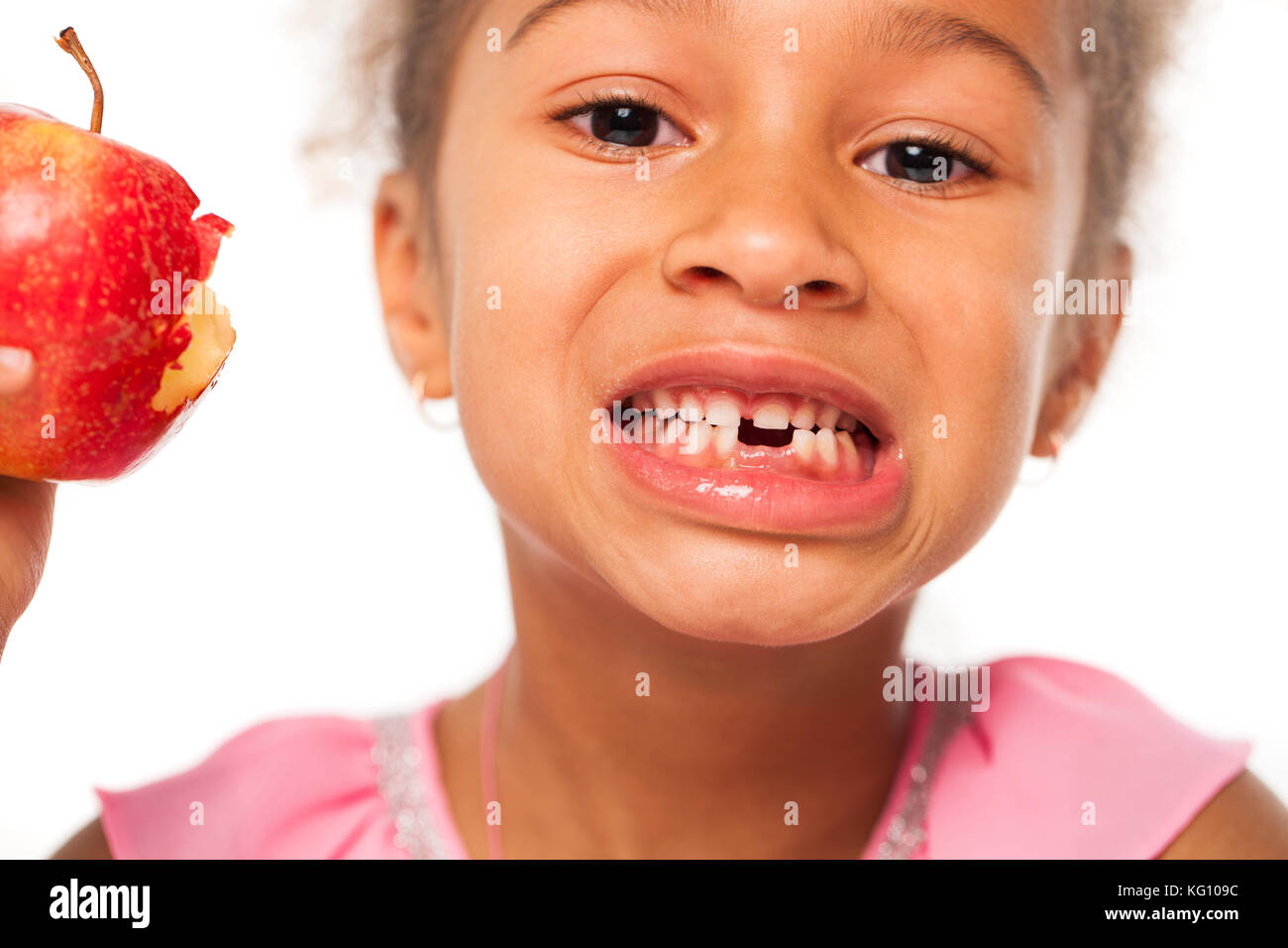 Сalfs teeth, Portrait of a pretty little girl with a red apple on white ...