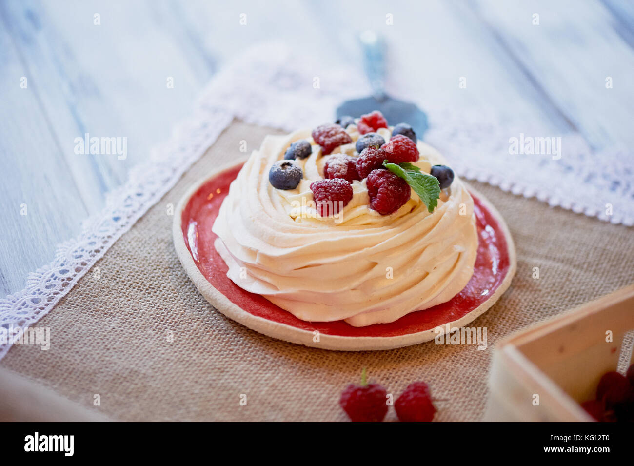 Dessert Anna Pavlova with raspberries and blueberries on white wooden ...