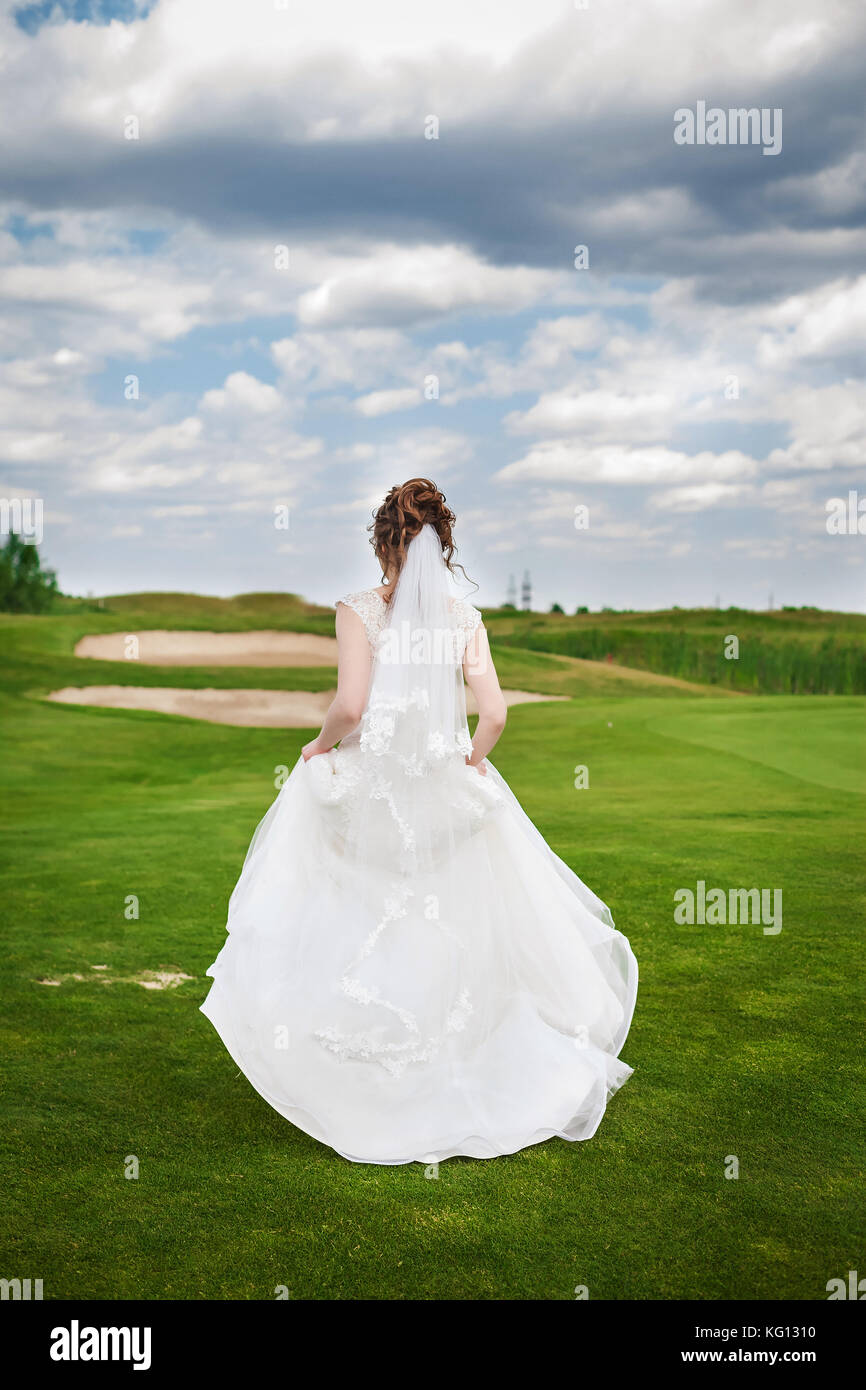 Bride on a field back view Stock Photo - Alamy