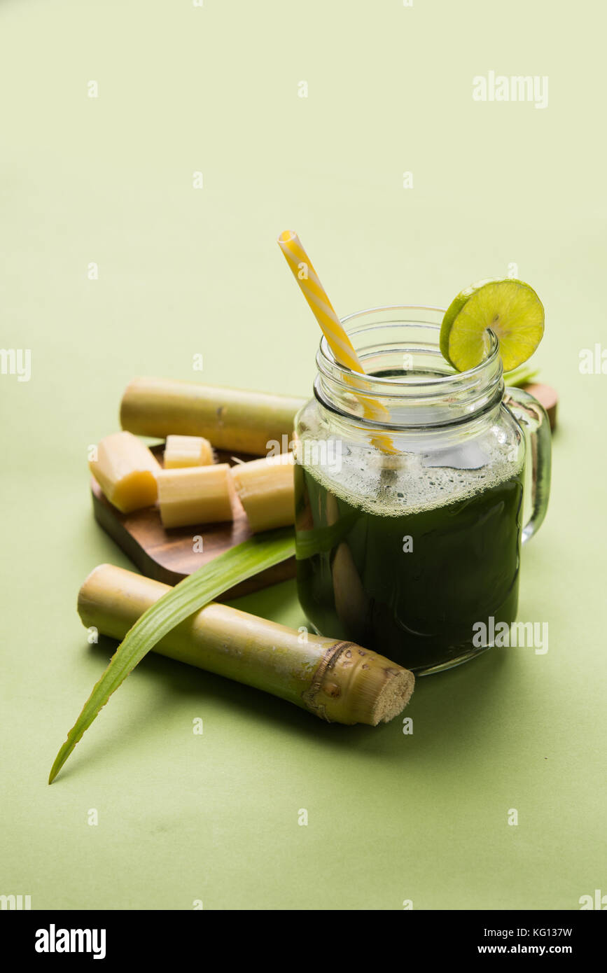 sugar cane juice or "ganne ka ras" with cut pieces cane on white ...