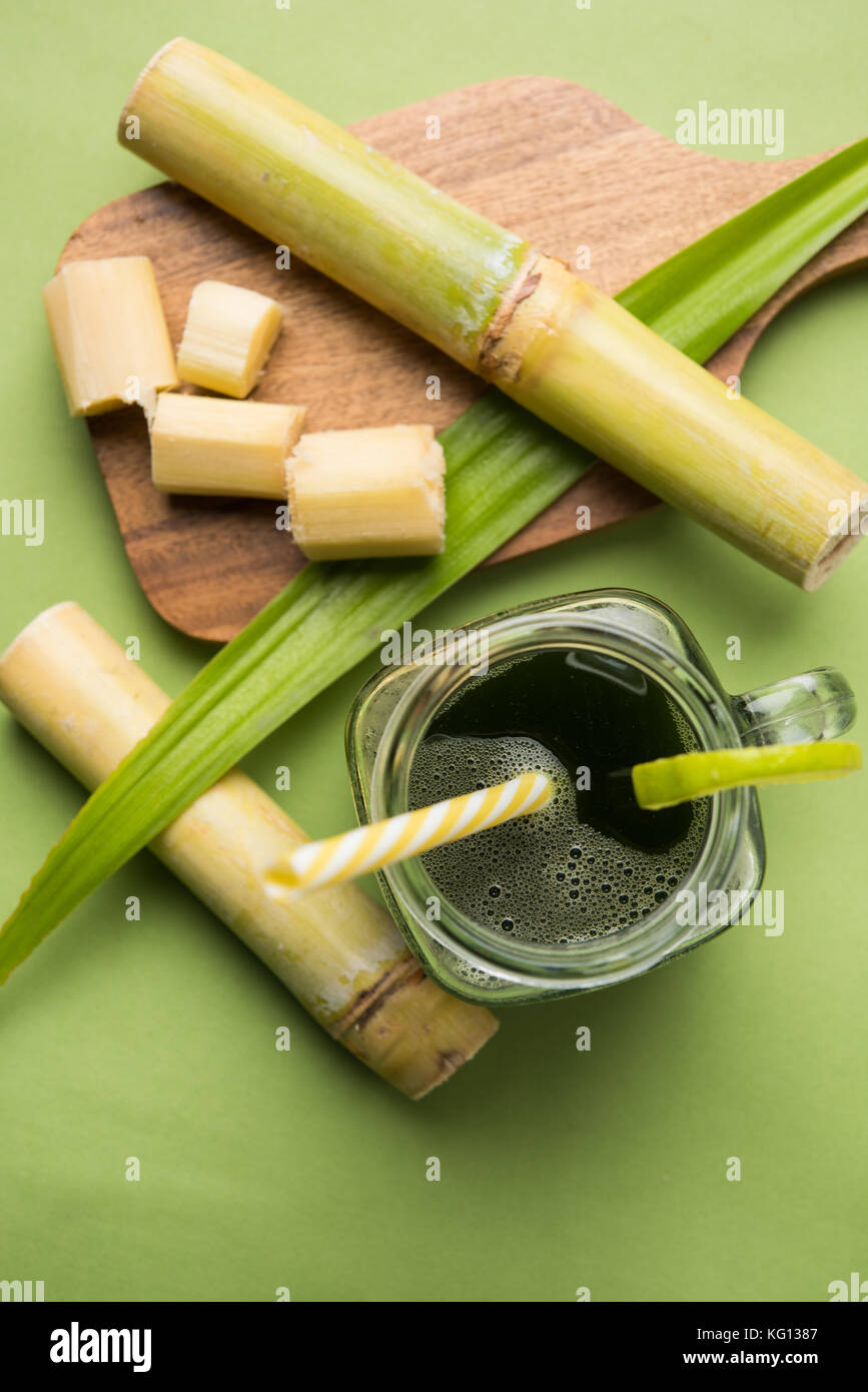 sugar cane juice or "ganne ka ras" with cut pieces cane on white ...