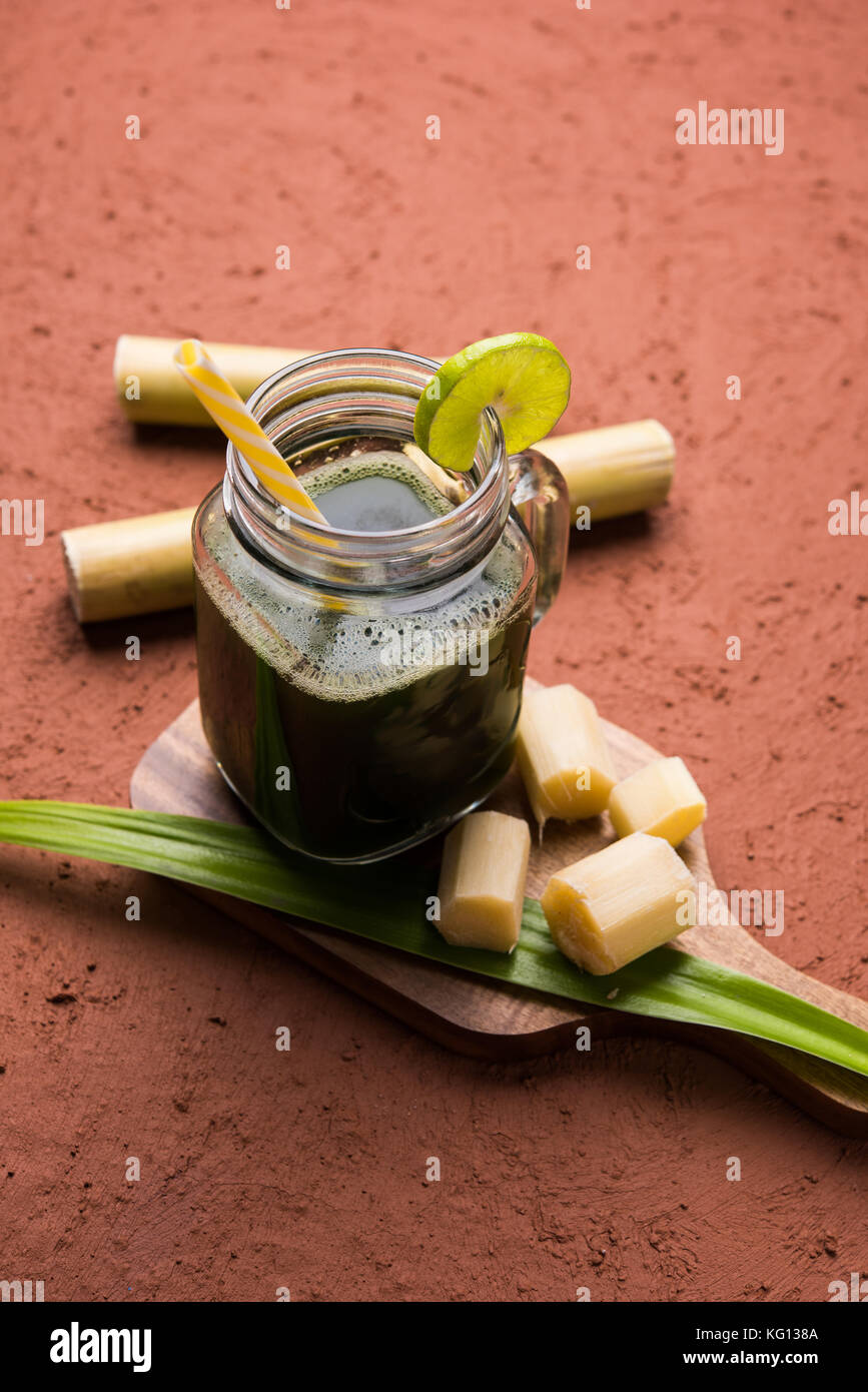 sugar cane juice or "ganne ka ras" with cut pieces cane on white ...