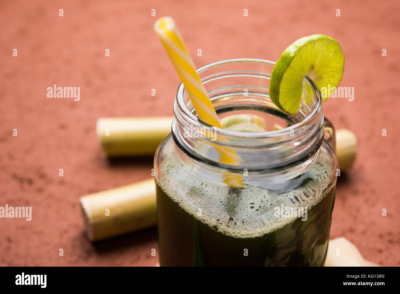 sugar cane juice or "ganne ka ras" with cut pieces cane on white ...