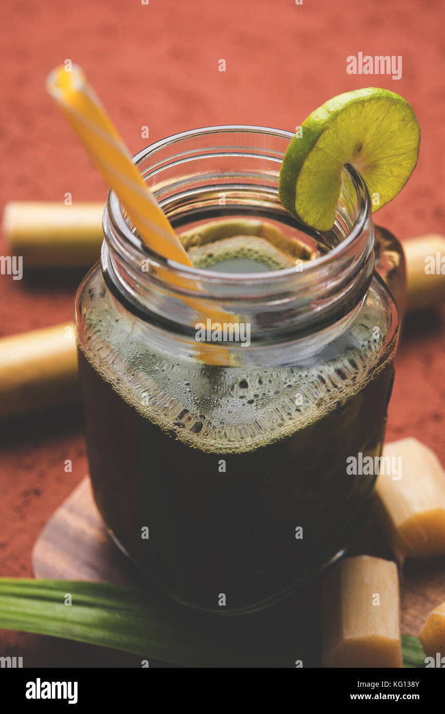 sugar cane juice or "ganne ka ras" with cut pieces cane on white ...