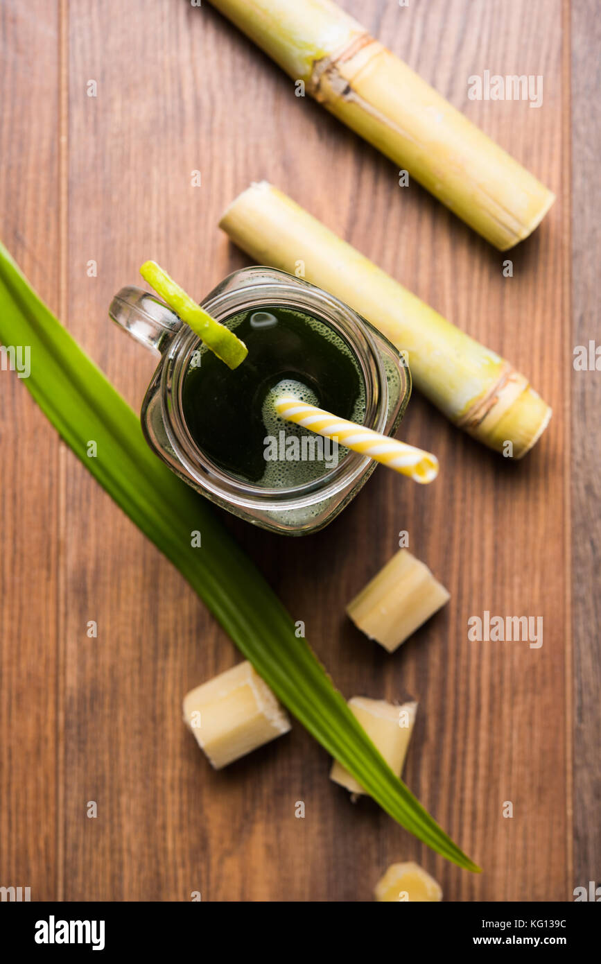 sugar cane juice or "ganne ka ras" with cut pieces cane on white ...
