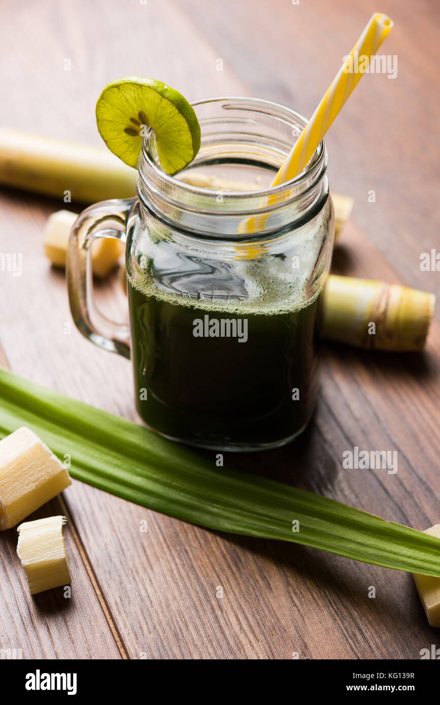 sugar cane juice or "ganne ka ras" with cut pieces cane on white ...