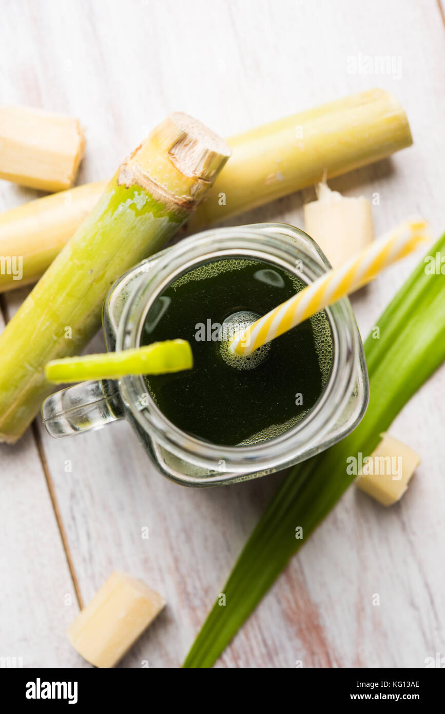 sugar cane juice or "ganne ka ras" with cut pieces cane on white ...