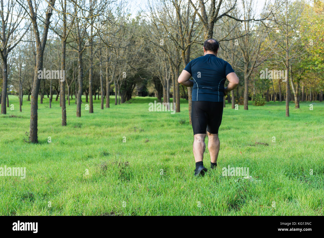 Big belly man jogging , exercising, doing cardio in the park , slightly ...