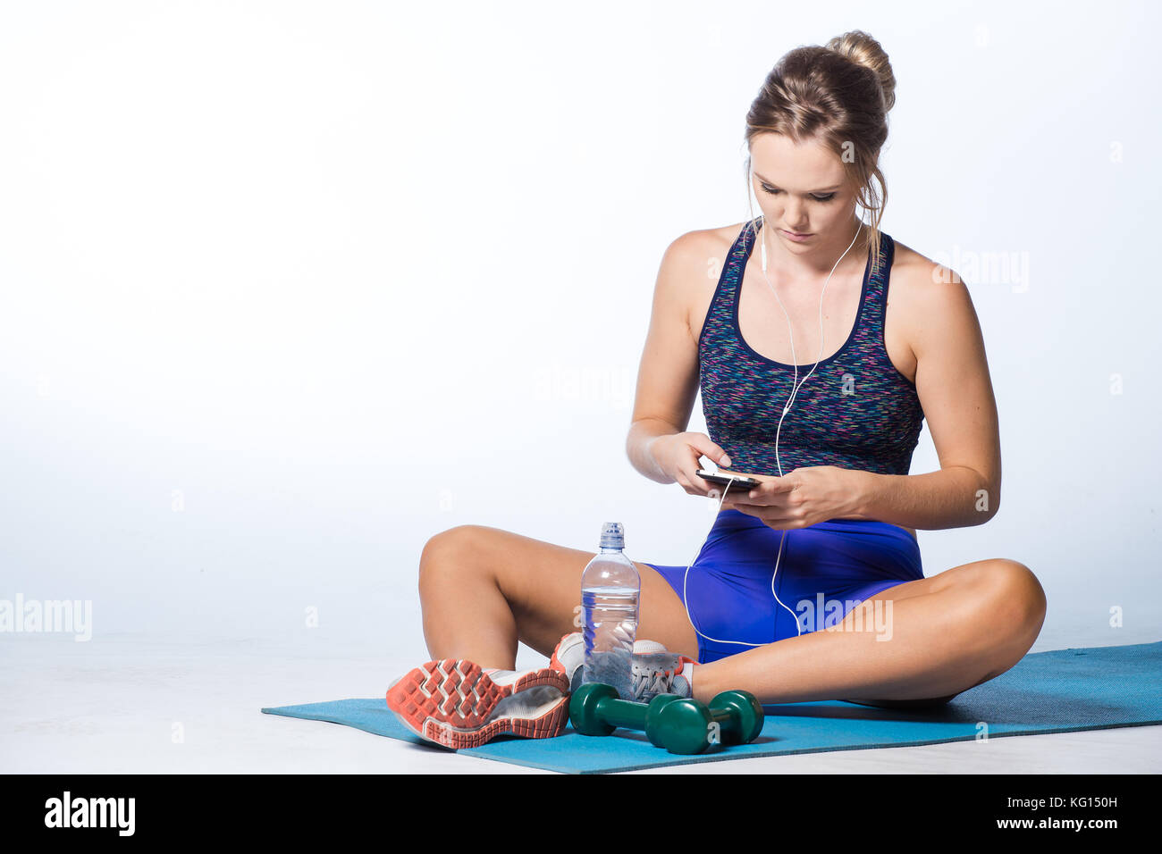 Female fitness model resting after an intense workout and taking some a ...
