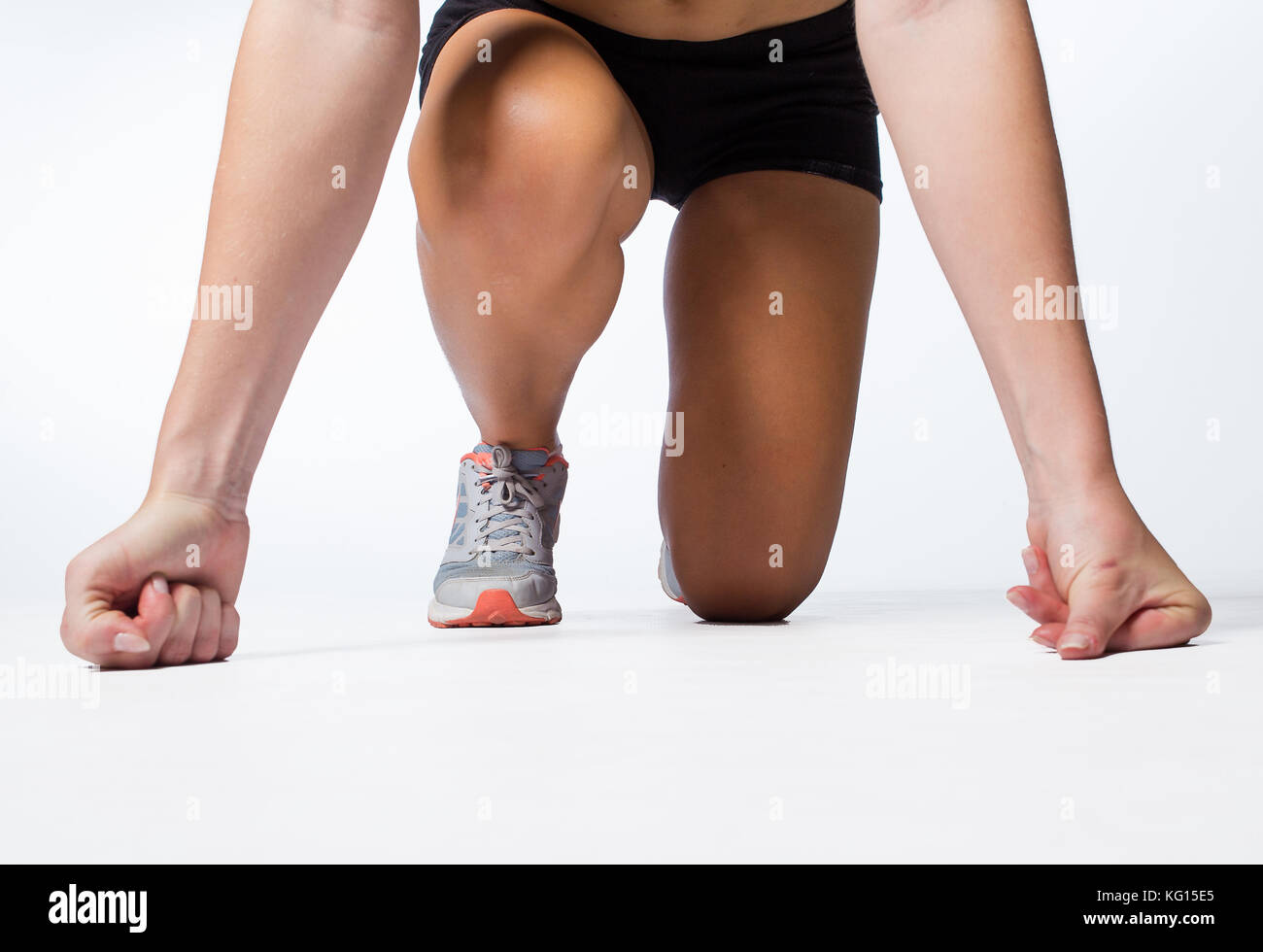 Beautiful fitness model in a studio getting ready for a sprint Stock ...