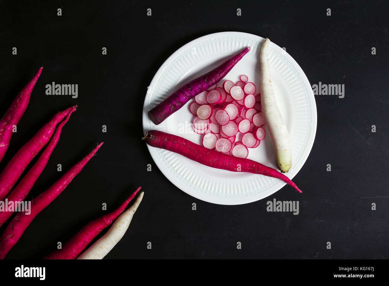 radish pink long, on a black background Stock Photo - Alamy