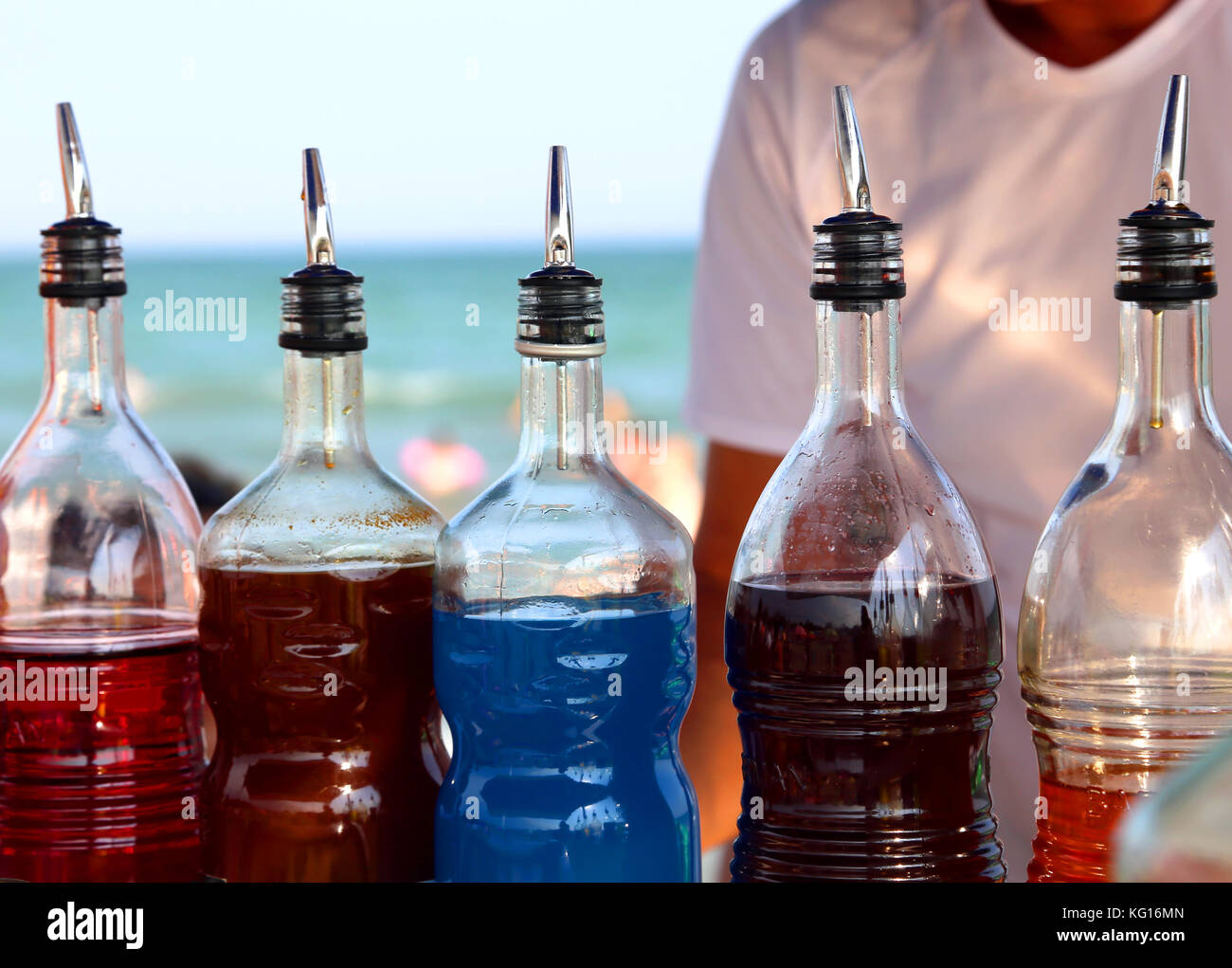 many bottles with sweetened syrup to prepare drinks on the beach by the ...