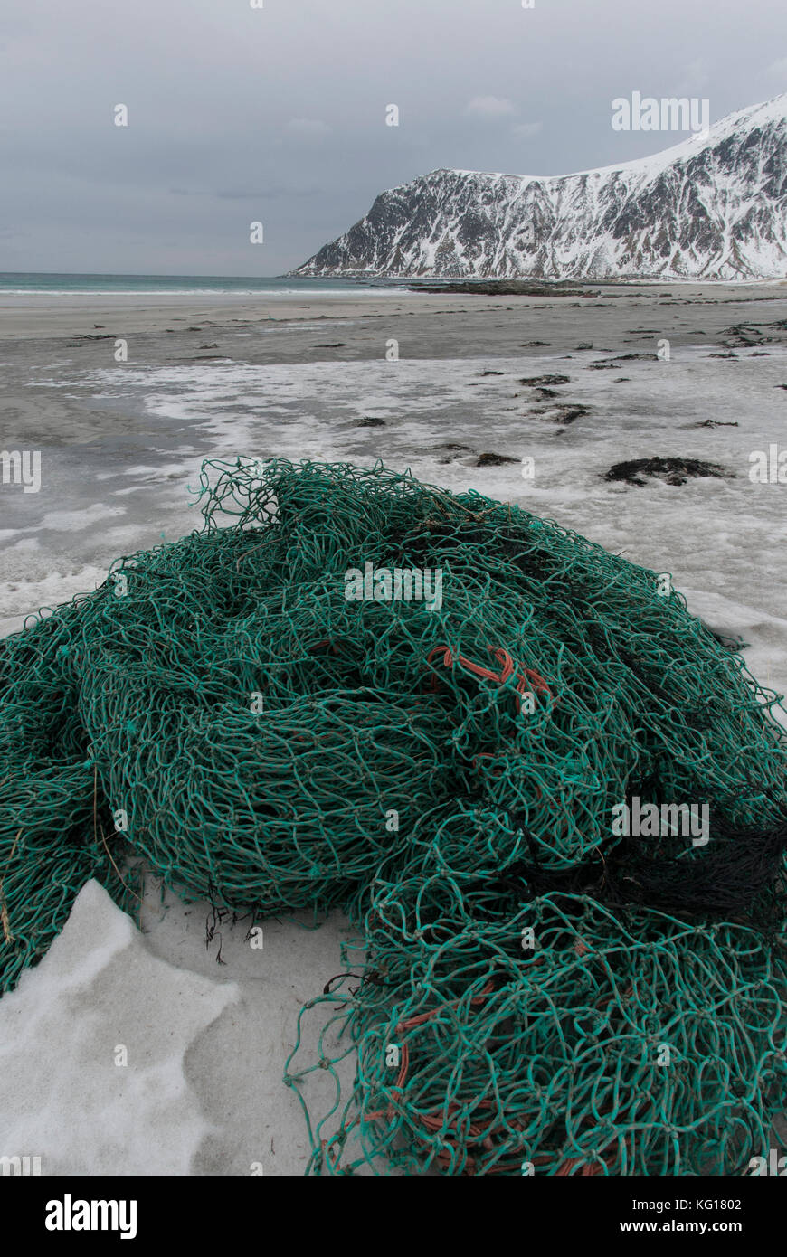 Plastic garbage and used fikshing nets on the sandy beach in Flakstad ...