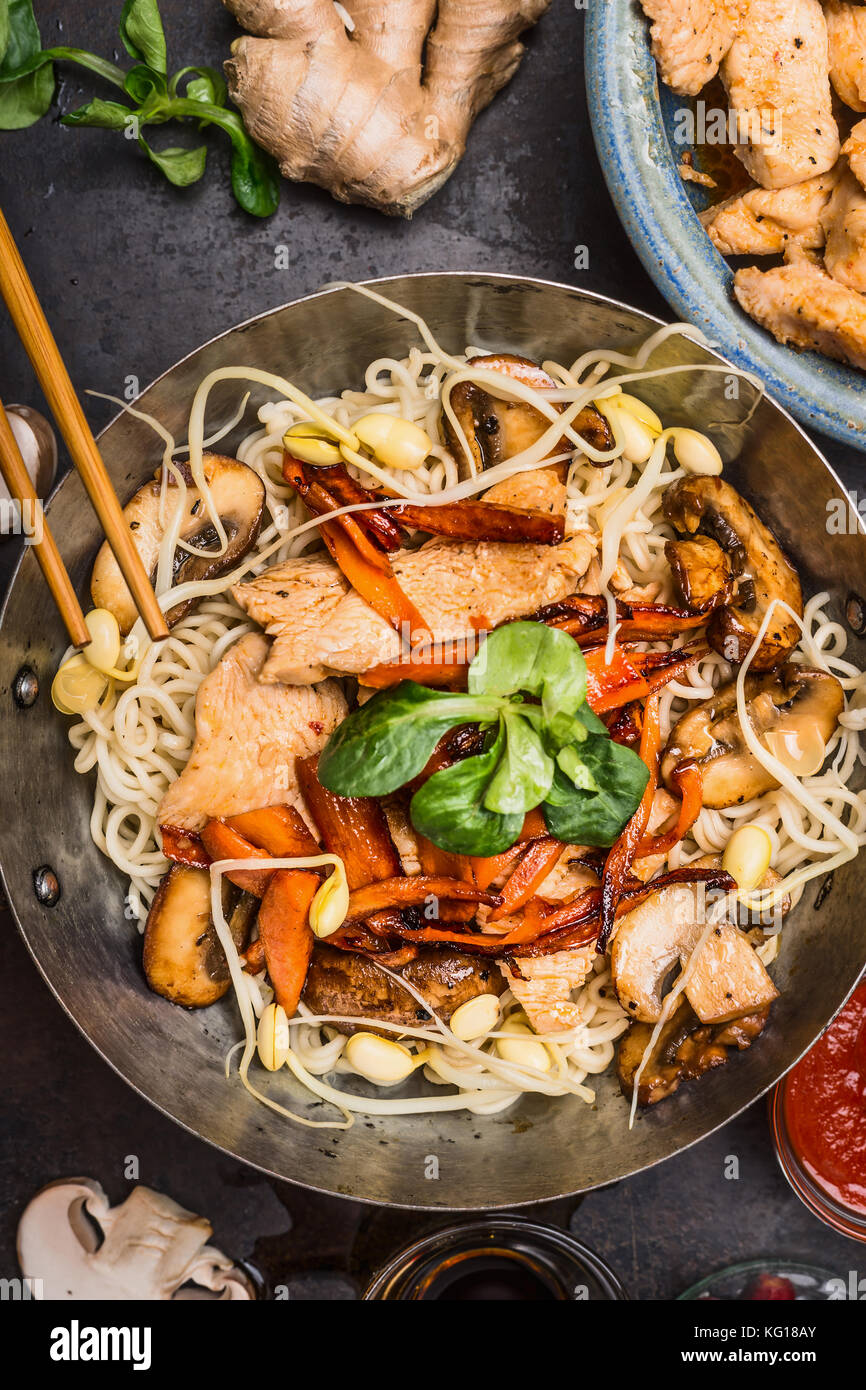 Wok with noodles chicken stir fry and chopsticks, top view, close up ...