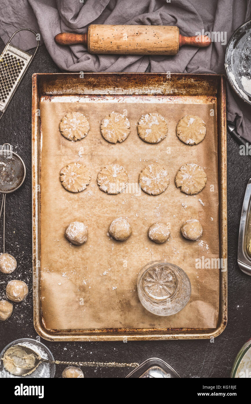 Flatten cookies with bottom of a drinking glass on baking tray ...