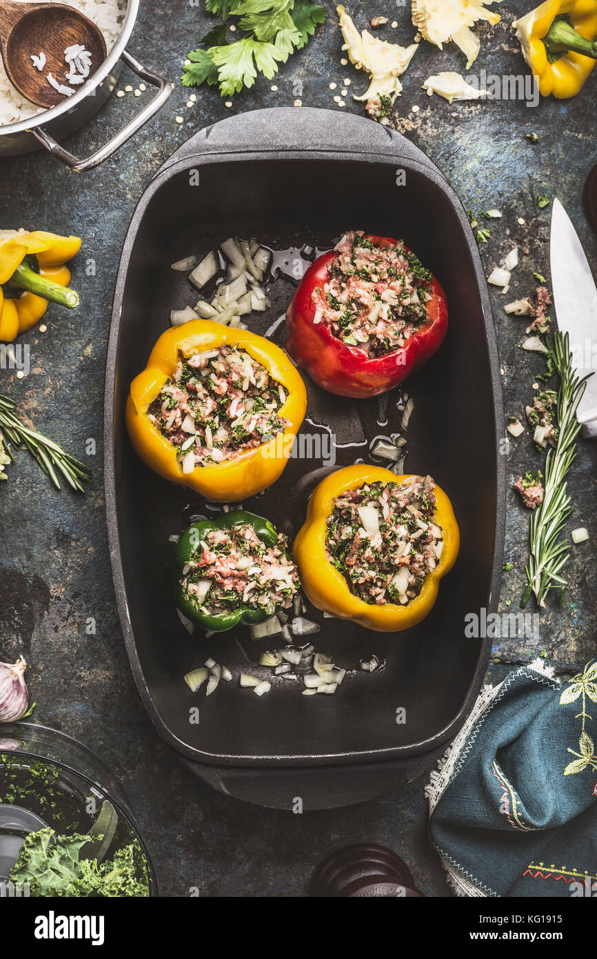 Colorful bell stuffed paprika peppers in iron cooking pot on dark ...
