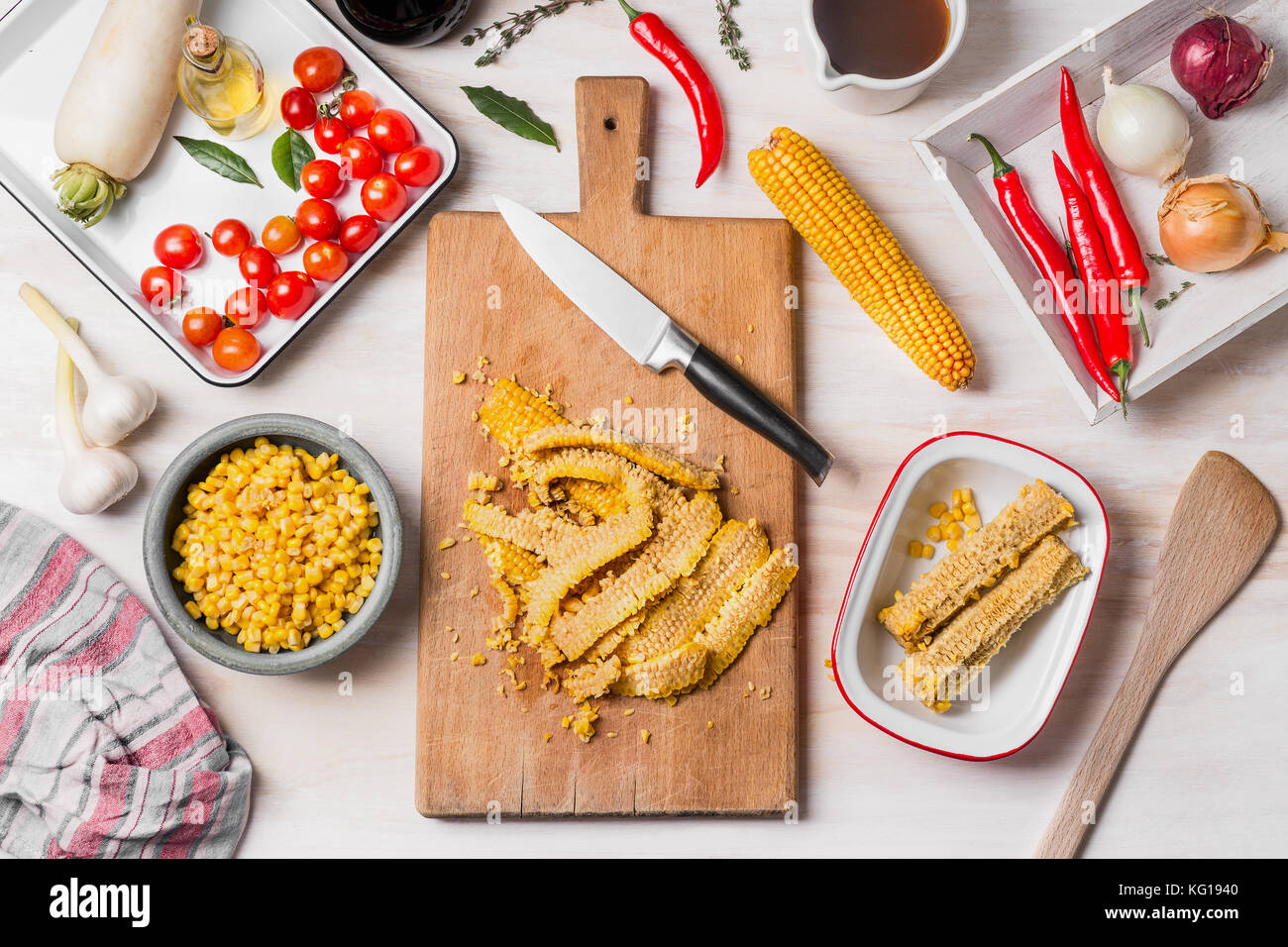 Corn cooking preparation with cutting board, knife and ingredients on ...