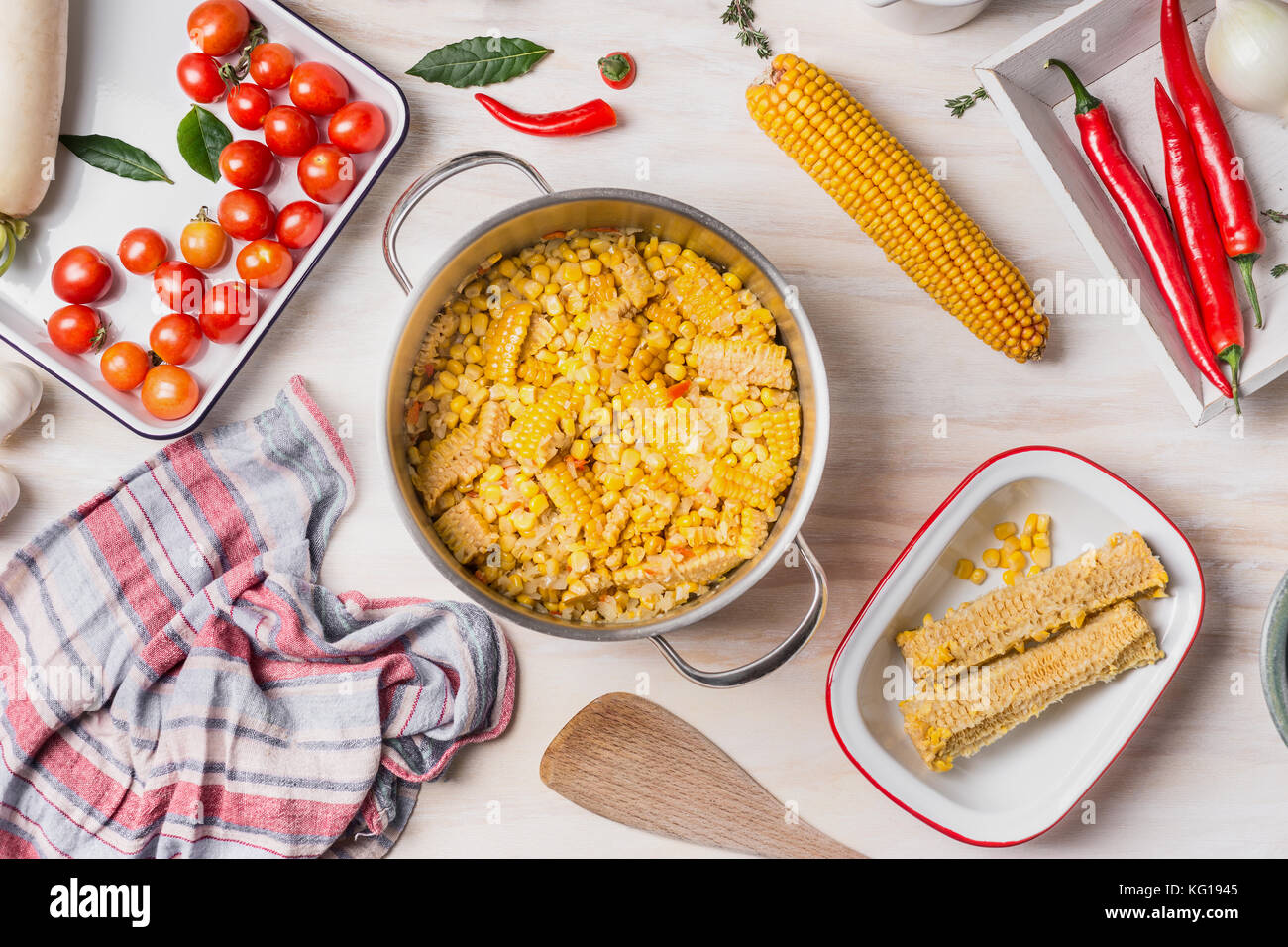 Corn cooking preparation with ingredients with pot and ear on white ...