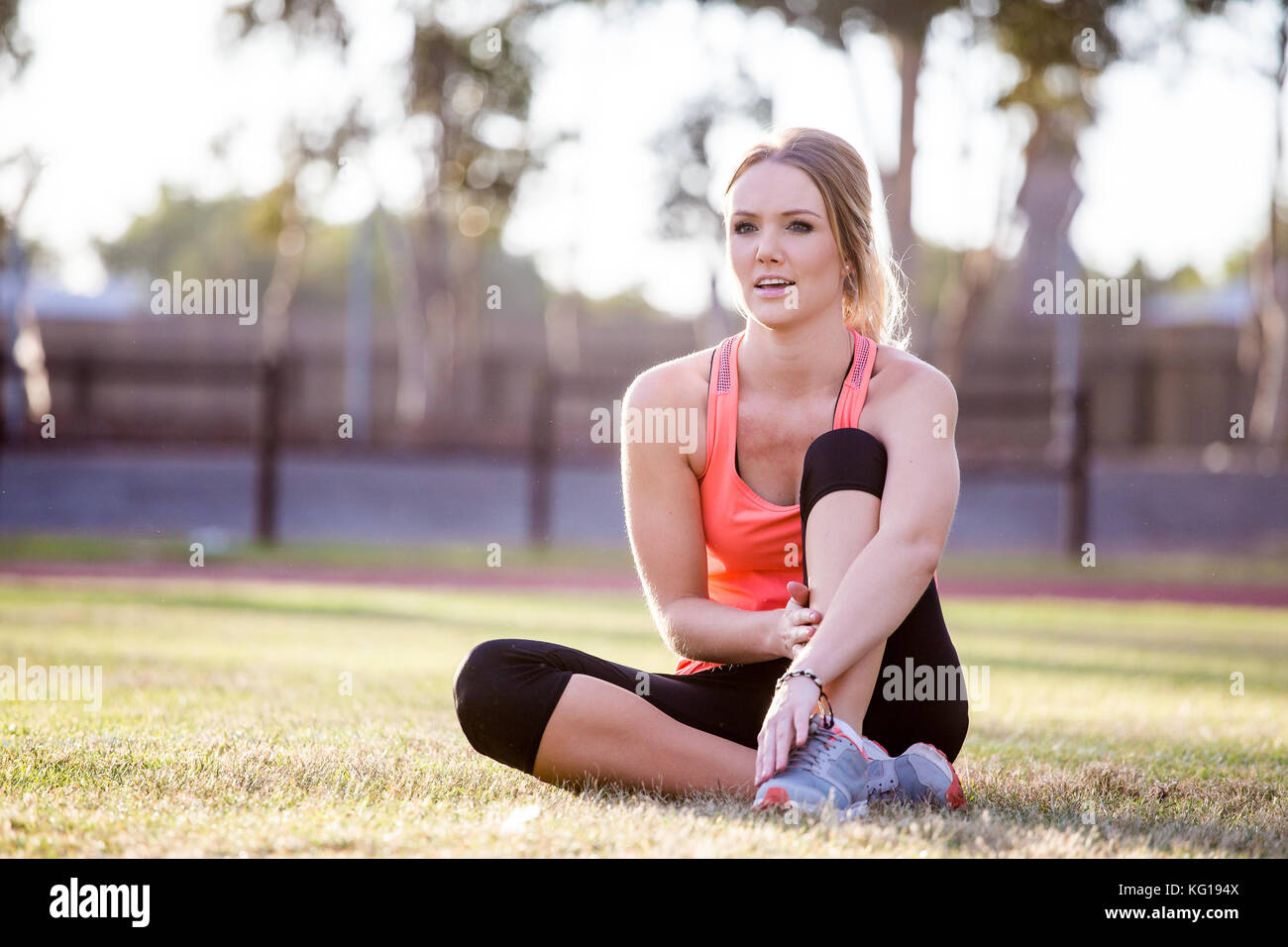Close up wide angle view of a female sprinter athlete getting ready to ...
