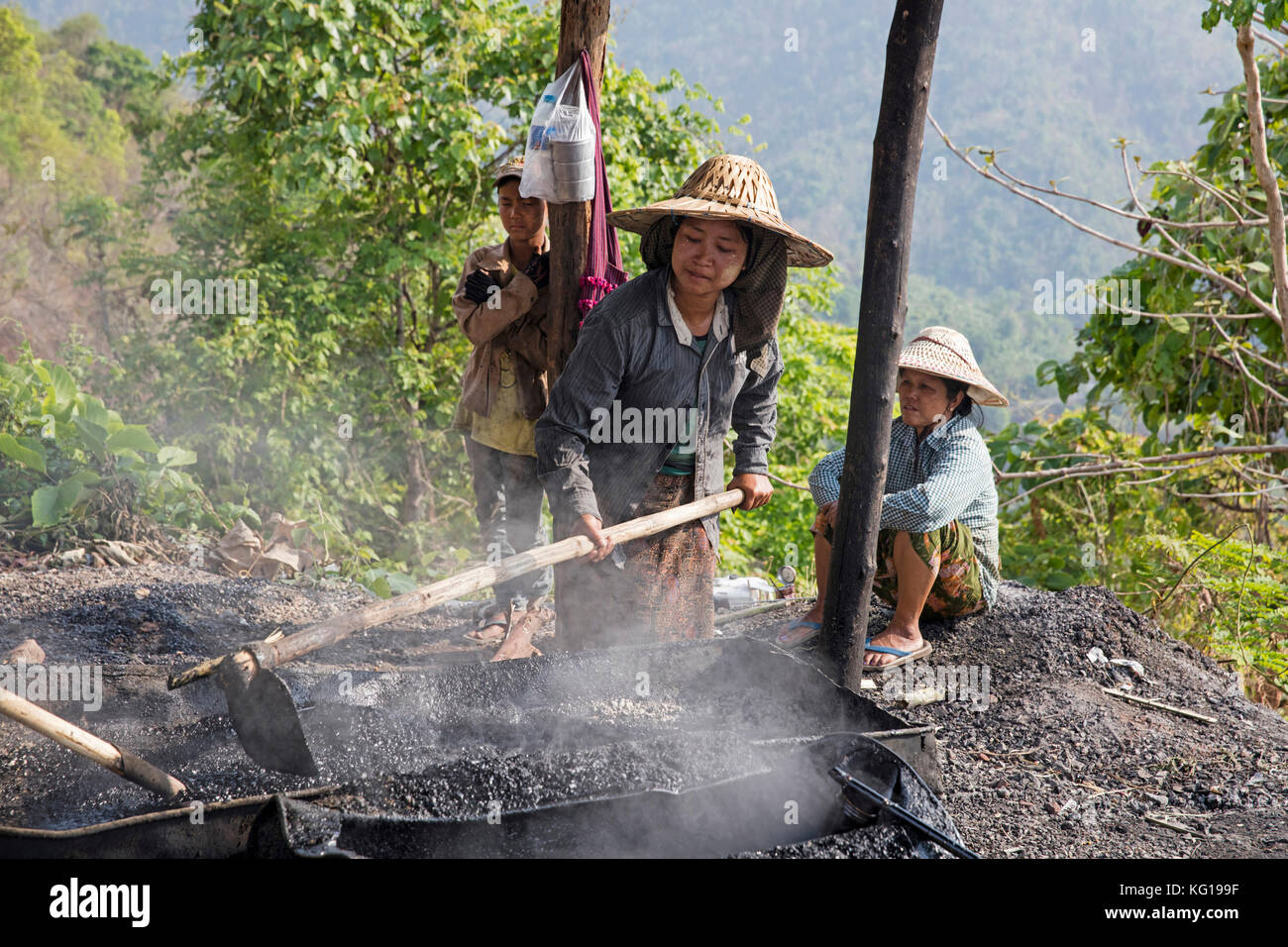Burmese female road workers / roadmenders producing tar to repair a ...