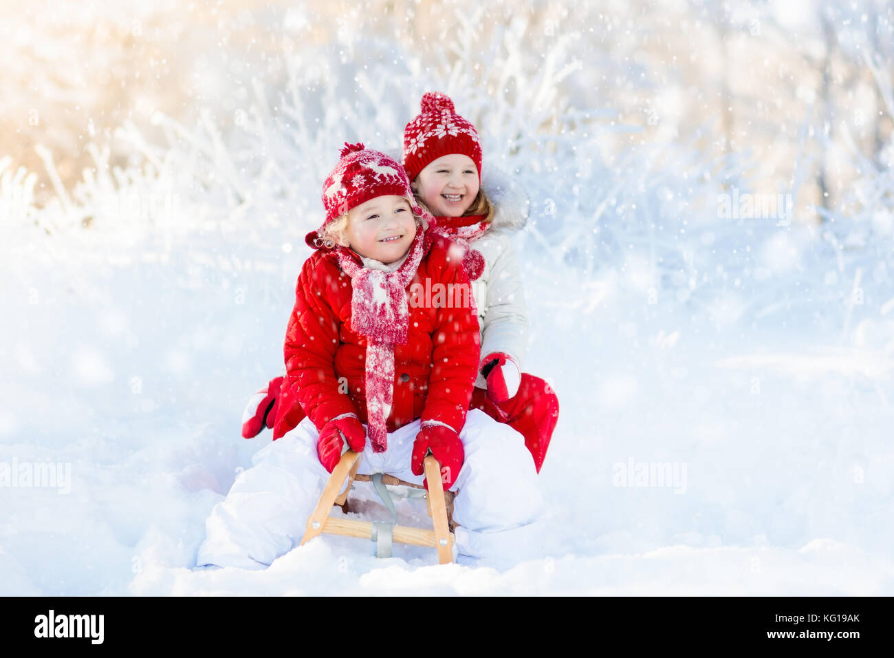 Little girl and boy enjoying sleigh ride. Child sledding. Toddler kid ...