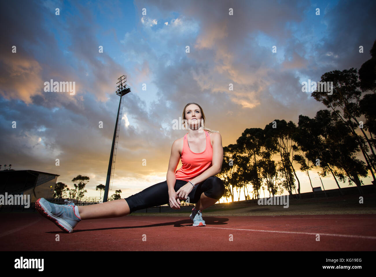 Close up wide angle view of a female sprinter athlete getting ready to ...
