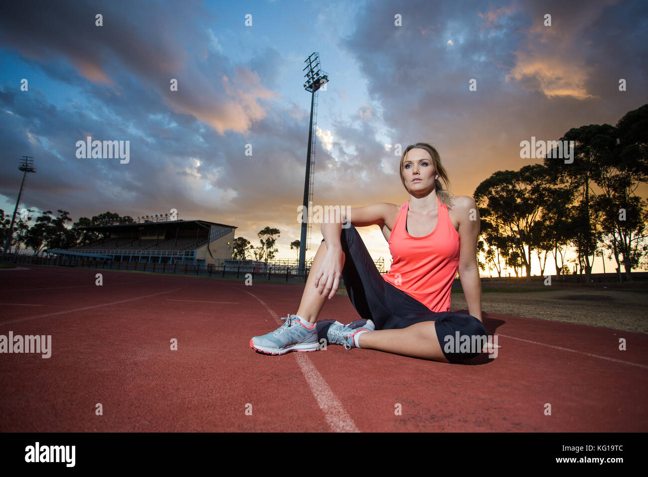 Close up wide angle view of a female sprinter athlete getting ready to ...