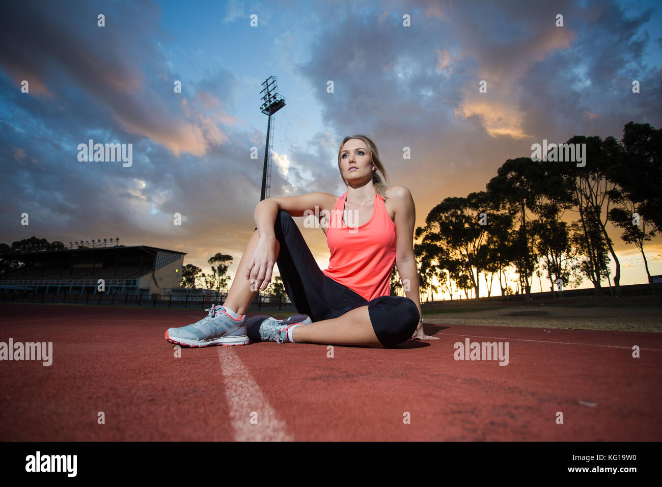Close up wide angle view of a female sprinter athlete getting ready to ...