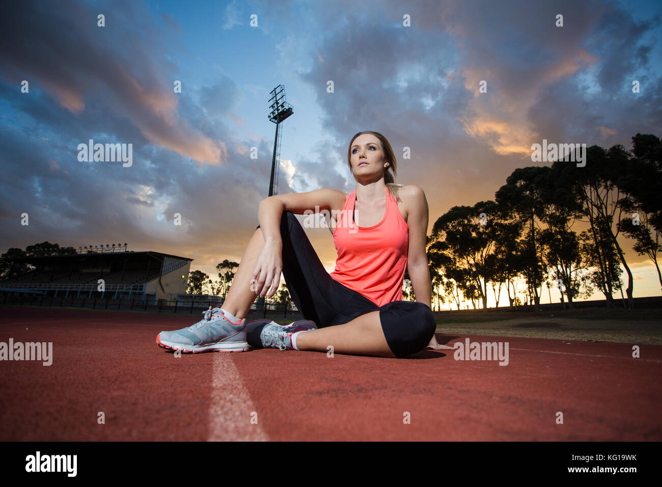 Close up wide angle view of a female sprinter athlete getting ready to ...