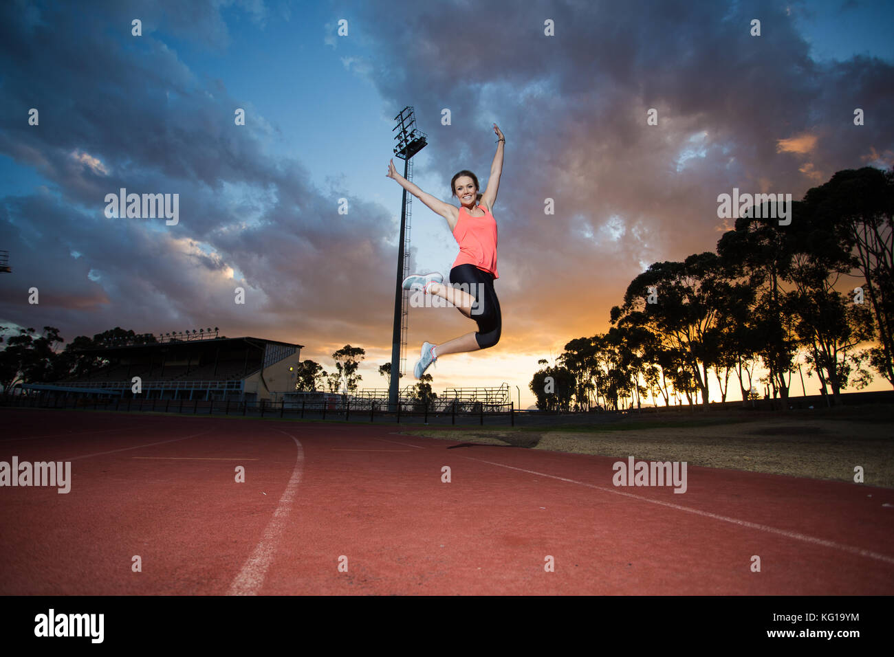 Close up wide angle view of a female sprinter athlete getting ready to ...