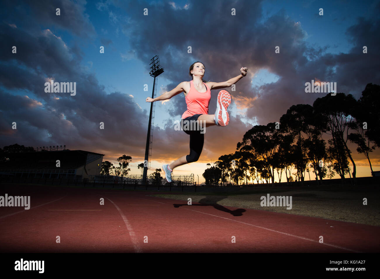 Close up wide angle view of a female sprinter athlete getting ready to ...