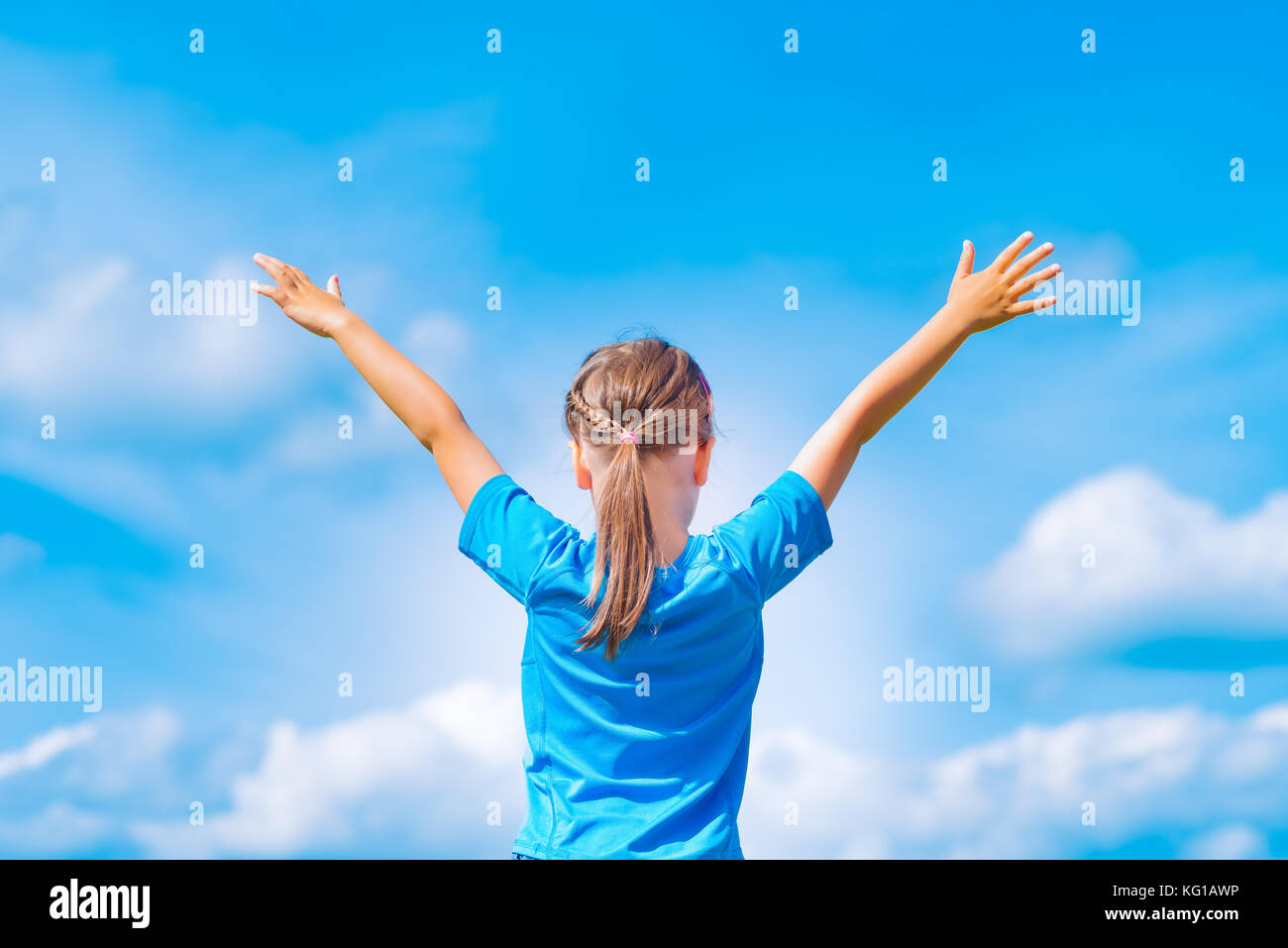 Happy child girl with open arms outdoor under blue sky. Young girl ...