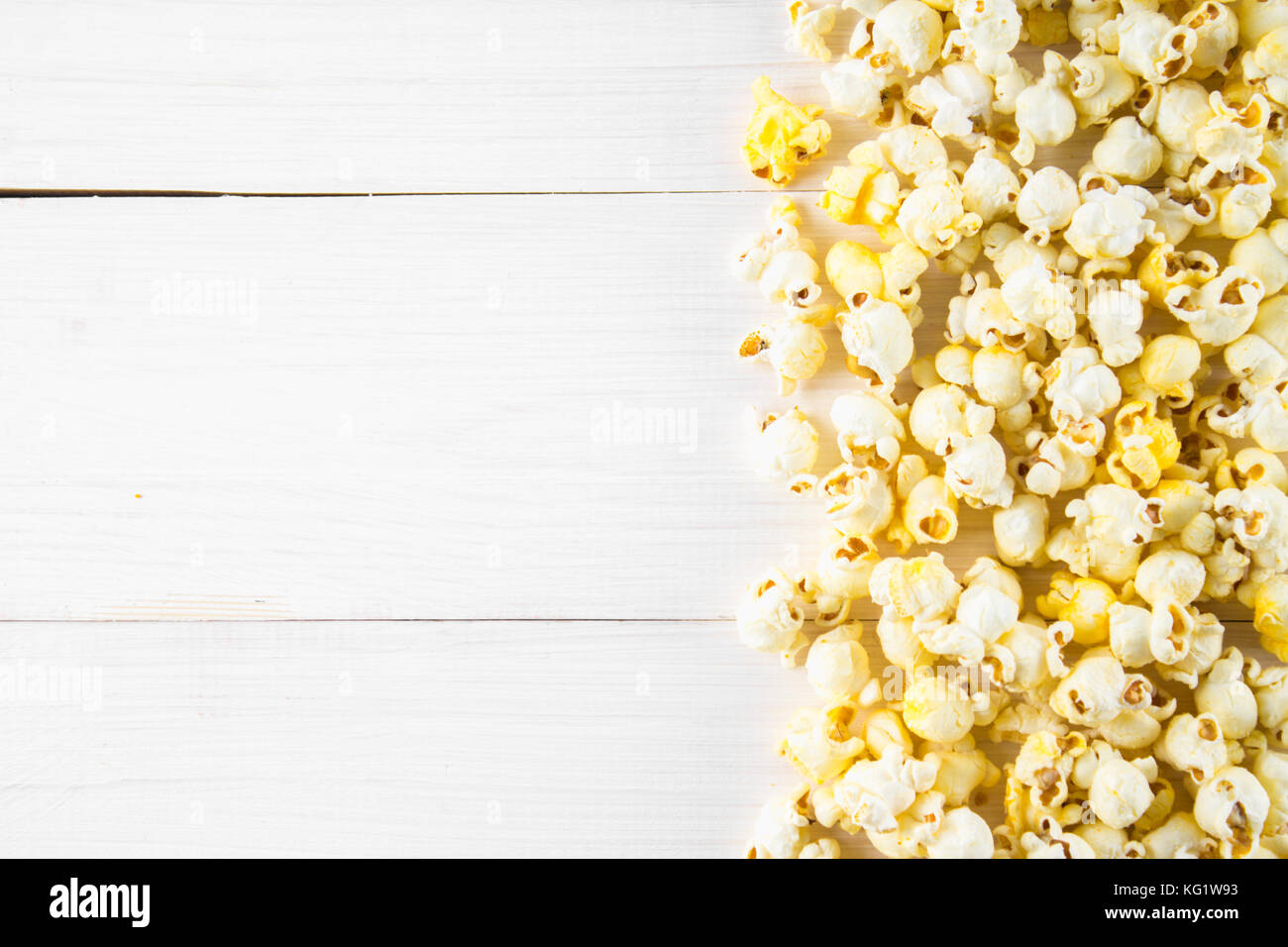 Salted popcorn on a white table. Top view. Empty space for text Stock ...