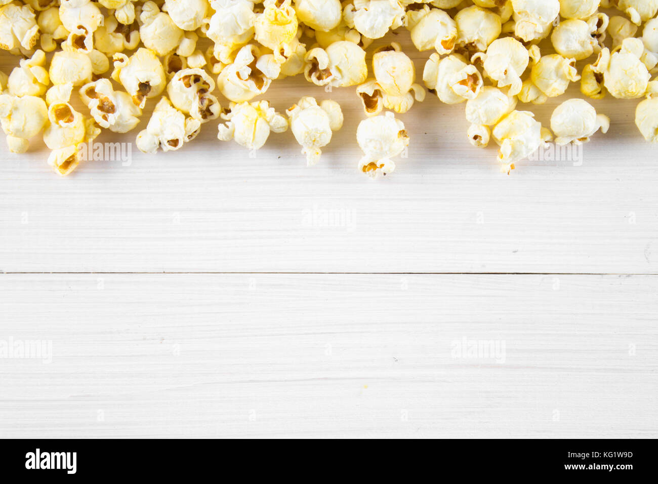 Salted popcorn on a white table. Top view. Empty space for text Stock ...