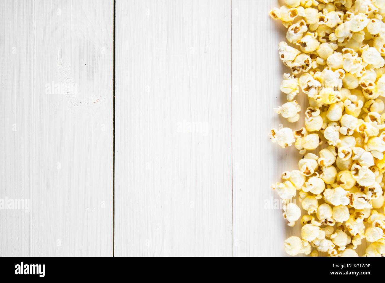 Salted popcorn on a white table. Top view. Empty space for text Stock ...